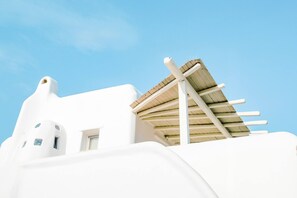 Um edifício branco com telhado inclinado e estrutura de madeira.