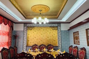 Quarto com teto alto, lustres elaborados e decoração de parede tradicional.