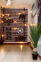 Um interior moderno com parede de ripas de madeira, luzes de corda, um adorno em formato de bóia salva-vidas e um vaso com planta.