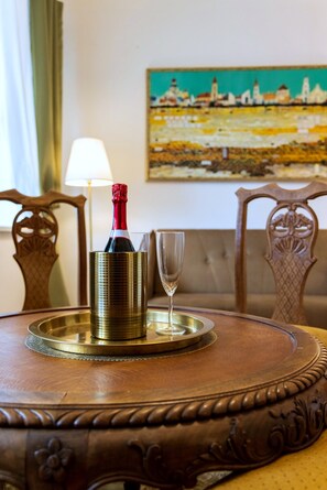 Uma mesa com uma garrafa de vinho tinto, uma taça e um bandeja.