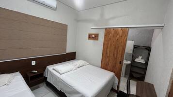 Quarto com cama, mesa de cabeceira e guarda-roupa.