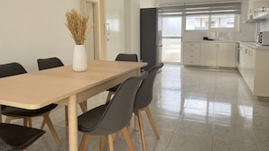 Uma cozinha moderna com armários brancos, forno embutido e micro-ondas.
