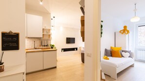 Uma sala de estar moderna com um sofá, uma televisão e uma lareira.