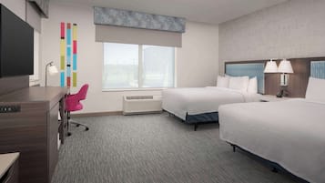 Quarto de hotel com duas camas, uma escrivaninha, televisão, luminária de mesa, cadeira, janela e parede com um design vertical colorido.