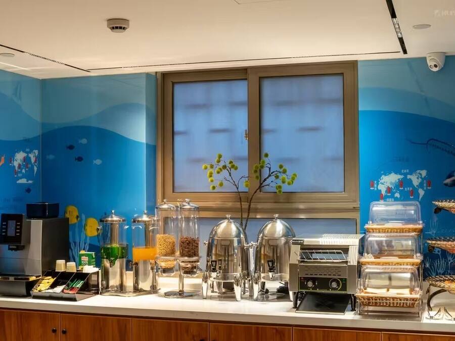 Uma mesa de pequeno-almoço com máquinas de café, distribuidores de comida e uma janela decorativa.
