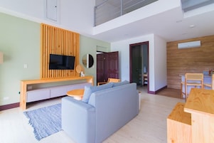 Uma sala de estar moderna com sofá, televisão e detalhes em madeira.