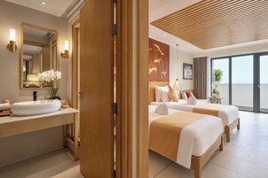 Quarto de hotel com uma janela grande, teto de madeira e duas camas.