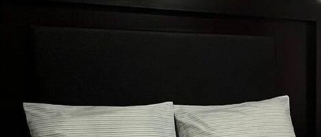 Quarto com uma cama, ventilador de teto e ar condicionado.