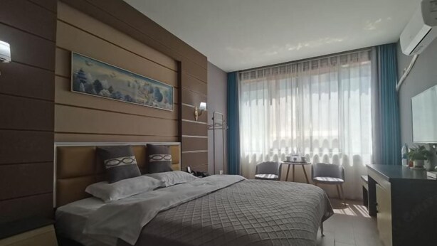 Quarto de hotel moderno com uma cama grande, uma mesa e uma cadeira.