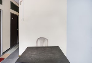 Quarto com uma mesa, uma cadeira, uma porta e uma tomada.