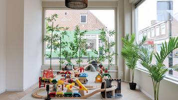 Espaço de recreação com um trem de brinquedo e plantas em vasos.