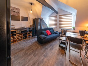 Um apartamento loft moderno com cozinha, área de jantar e um espaço de estar aconchegante com sofá e mesa de jantar.