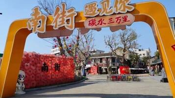 Um arco chinês tradicional com um fundo floral vermelho e uma placa.