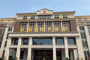 Um edifício com uma placa que diz 'Cayman International' e outra com caracteres chineses.