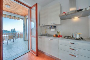 Apartamento Familiar, 2 quartos, junto à montanha (La Perla Bianca Lake View) | Cozinha privada | Um frigorífico, um micro-ondas, um forno, uma placa de cozinha