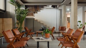 Uma área de estar moderna com poltronas de couro, uma mesa de centro e plantas em vasos.
