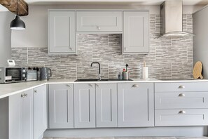 Um frigorífico, um micro-ondas, um forno, uma placa de cozinha 