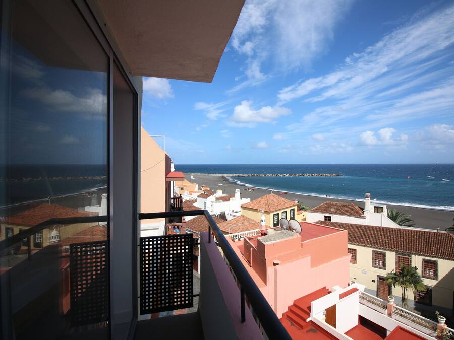 Vista costeira de uma varanda com vista para a praia e o oceano.