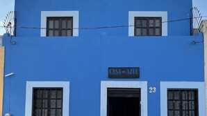 Um edifício azul com uma placa que diz 'CASA AZUL' e o número '23' na fachada.