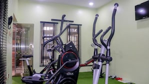 Uma academia com bicicletas ergométricas, esteira e remo.