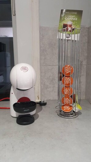 Máquina de café e um expositor com cápsulas de café.