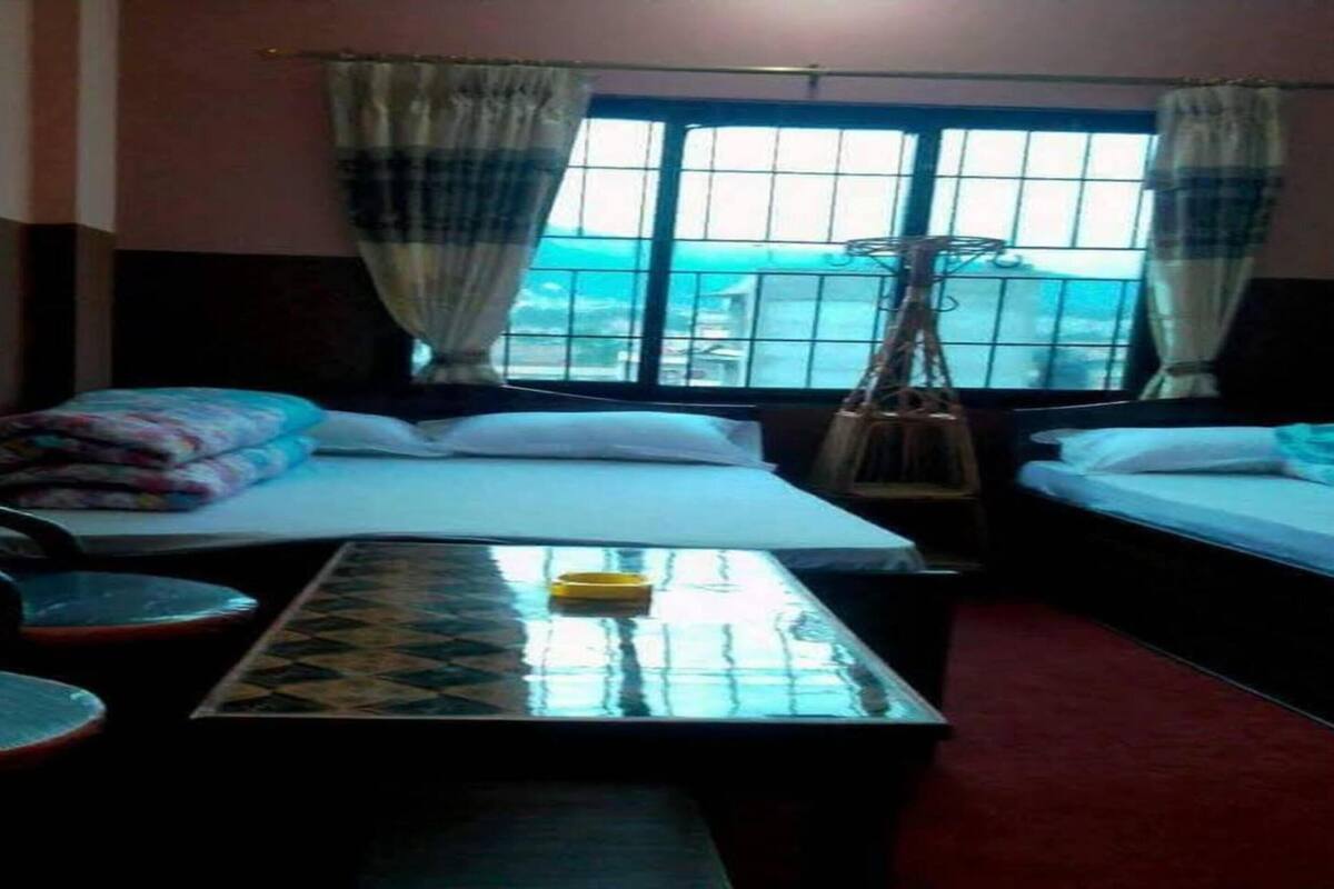 Quarto com duas camas, uma mesa e uma cadeira.