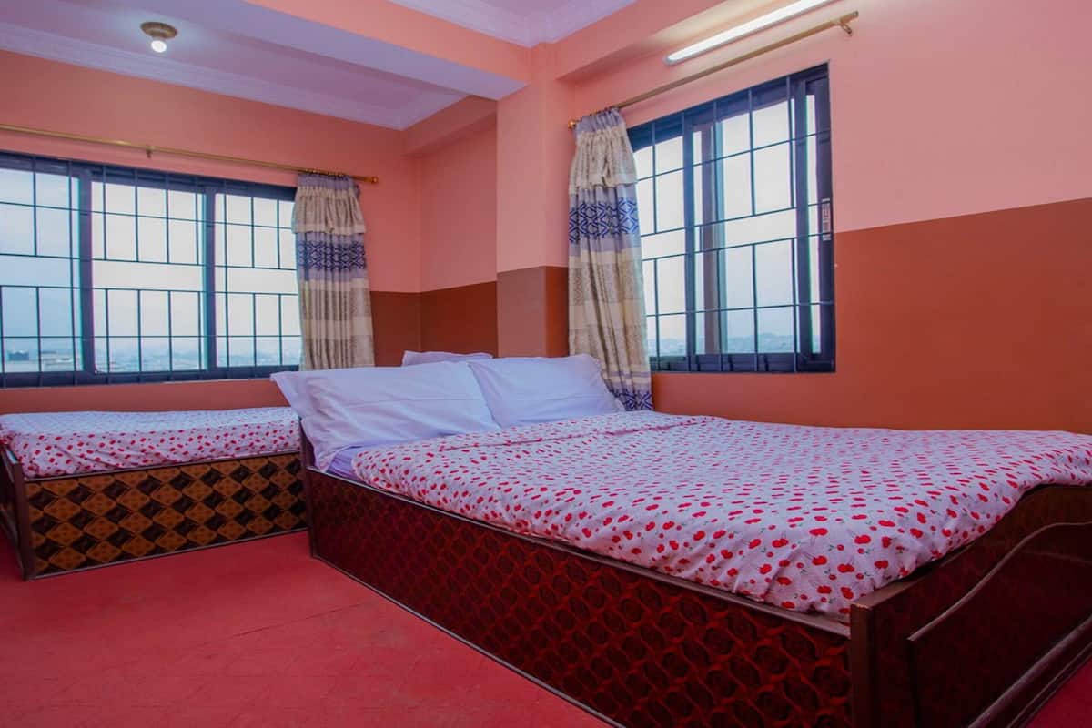 Quarto com duas camas, janelas amplas com cortinas e um tapete vermelho.