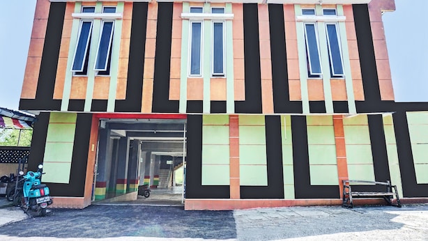 Um edifício de vários andares com design moderno, caracterizado por grandes janelas e um telhado plano.