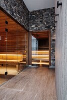 Interior moderno com parede de pedra, banco de madeira e divisórias de vidro.