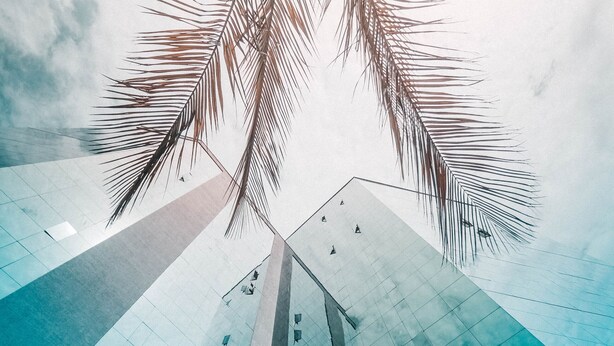 Um edifício moderno com fachada de vidro e a inscrição “BORA HOTEL” visível na entrada.
