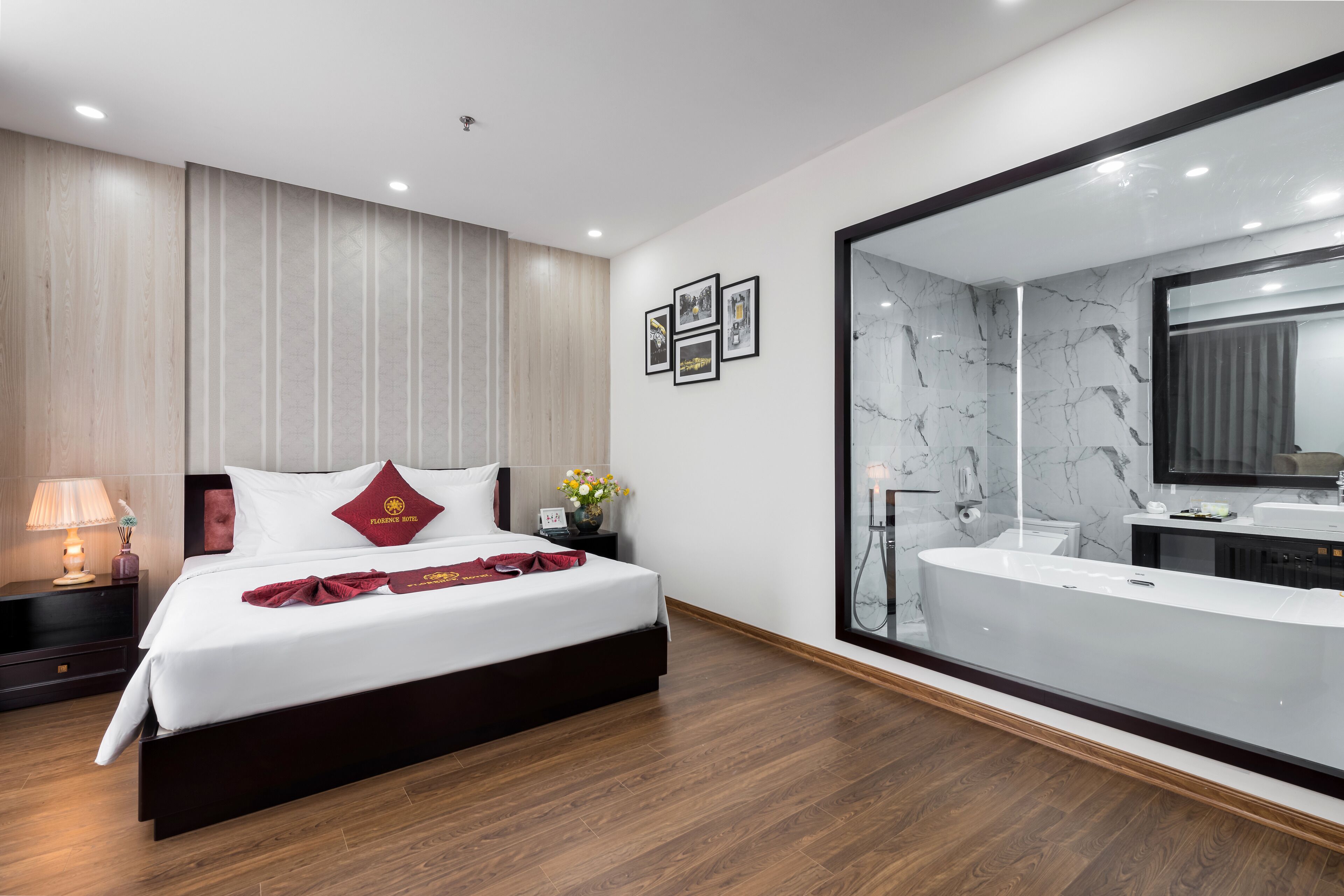 Quarto de hotel moderno com uma cama grande, banheiro separado com banheira e um espelho amplo.