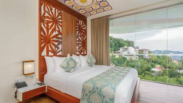 Quarto de hotel com uma cama grande, uma mesinha de cabeceira com telefone e vista para a paisagem urbana através de amplas janelas.
