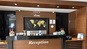 A reception desk with a world map, a sign reading "YAHURI HOTEL," and a "Reception" sign.