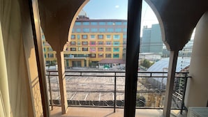 Uma varanda com vista para um prédio de vários andares com fachadas coloridas.