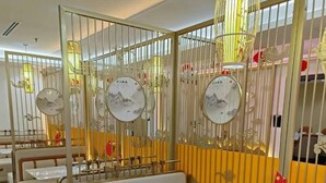Um restaurante com assentos em cabines e uma mesa posta para dois.