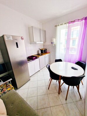 Um frigorífico, um micro-ondas, um forno, uma placa de cozinha 