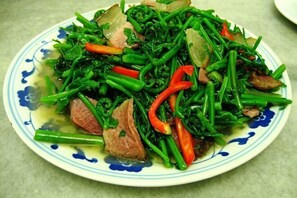 Um prato de legumes e carne salteados.