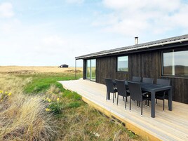 Uma casa moderna com varanda, área de estar externa e vista para a paisagem.