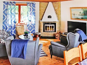 Uma sala de estar com lareira, televisão e um ambiente acolhedor.