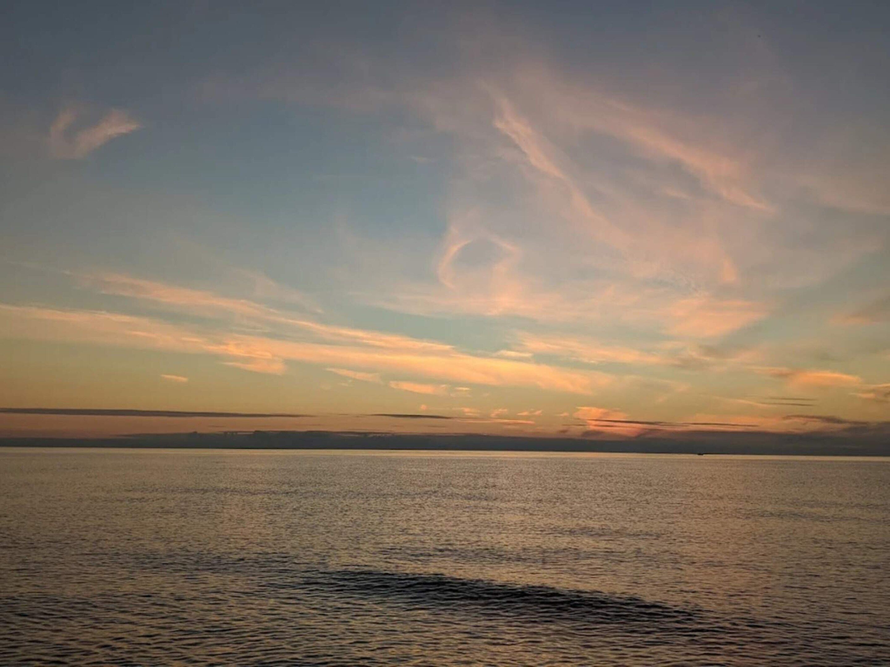 Água calma com horizonte e céu claro.