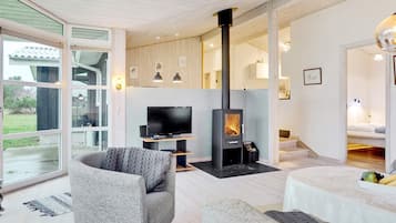 Uma sala de estar moderna com lareira, televisão e assentos confortáveis.