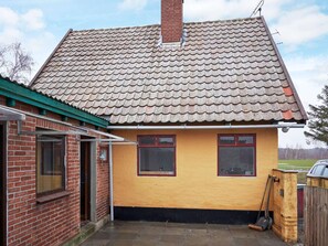 Uma casa de dois andares com telhado ladrilhado e fachada de tijolo.