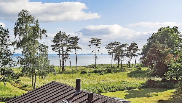 Terraço com vista para um lago e árvores.