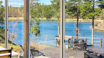 Um deck à beira do lago com móveis externos e vista para o lago.