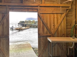 Uma cabana de madeira com vista para um cais e barcos.