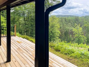Um deck de madeira com vista para uma área arborizada.