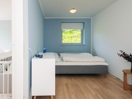 Quarto com cama, mesa de cabeceira, janela e berço.