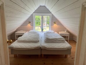 Quarto com duas camas, uma janela e abajures.