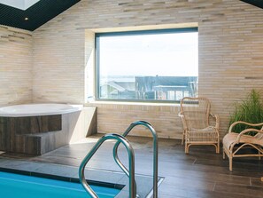 Área interna de piscina moderna, com vista para edifícios através de uma grande janela.