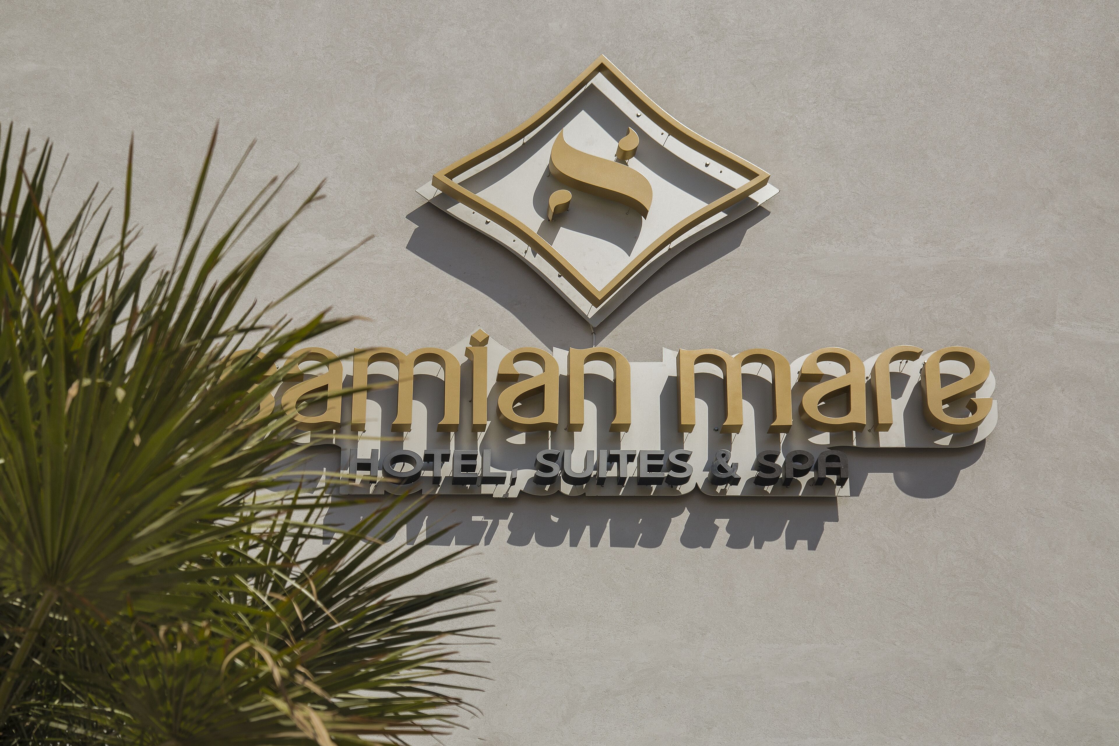 Placa de hotel com logotipo e o nome 'Amian Mare Hotel, Suites & Spa'.